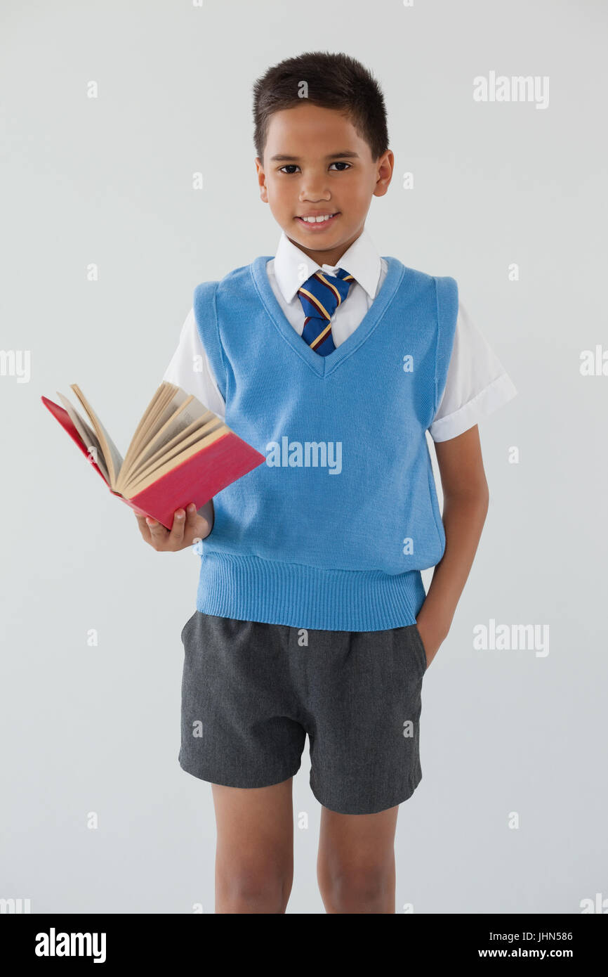 Portrait of schoolboy standing in front of chalkboard in classroom at ...