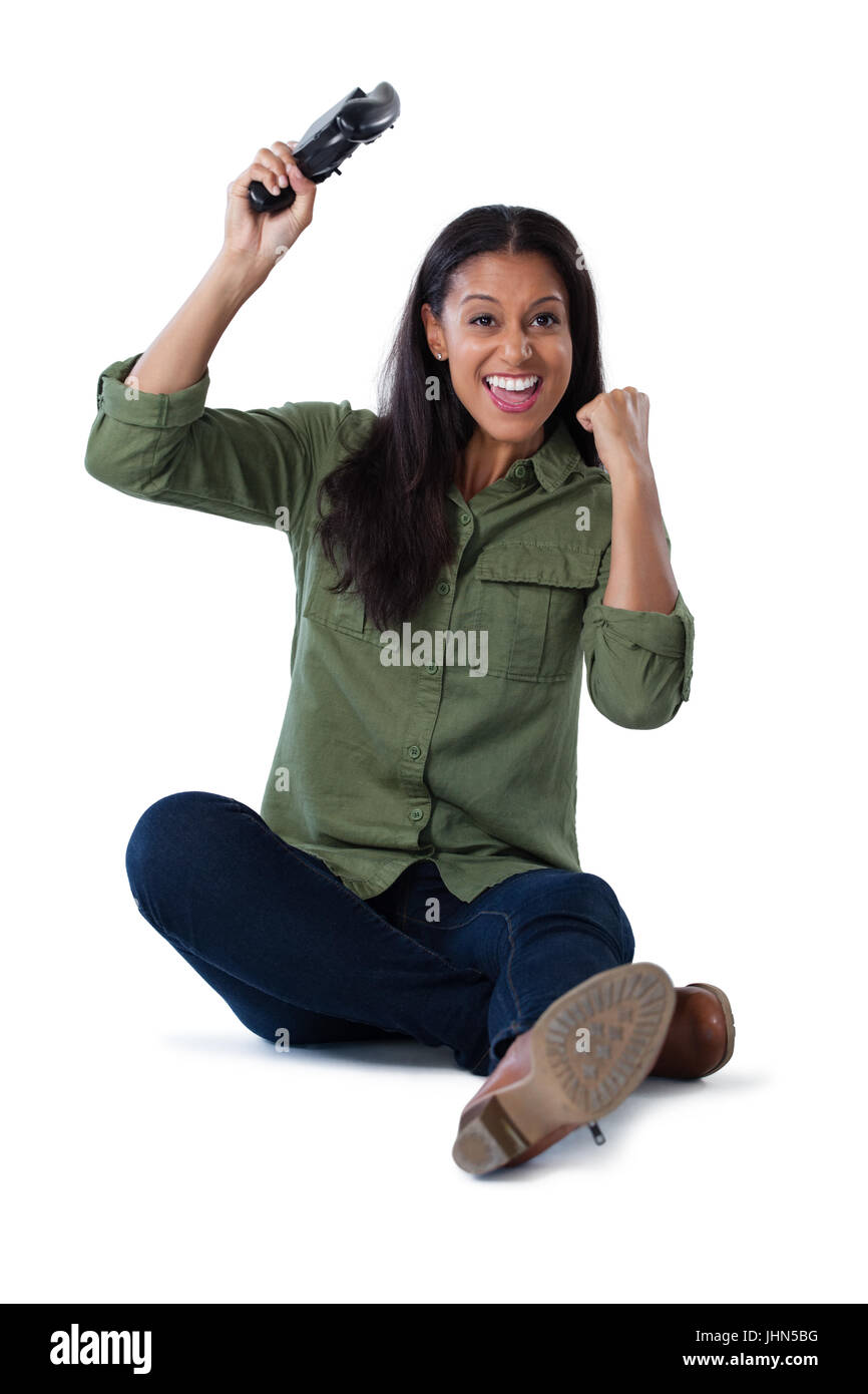 Excited woman playing video games against white background Stock Photo ...