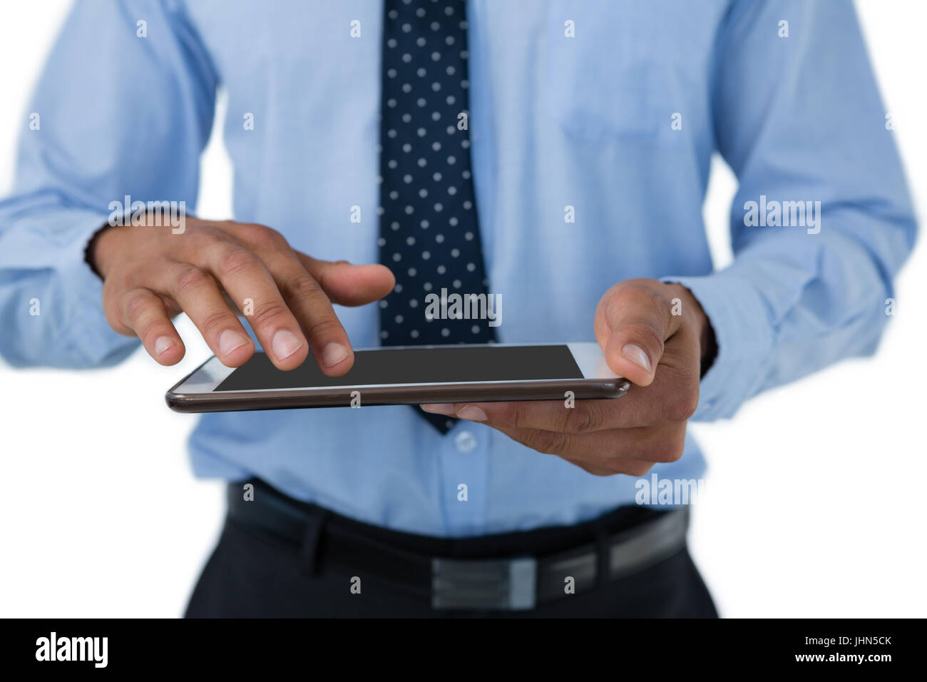 Mid section of businessman touching tablet computer while standing ...
