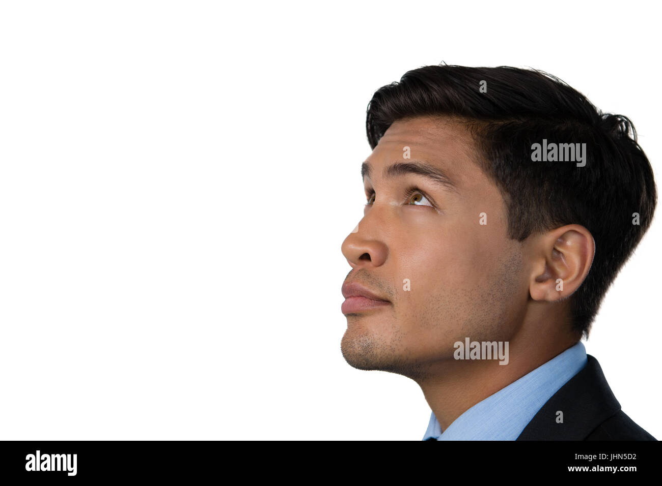 Side view of businessman looking up against white background Stock ...