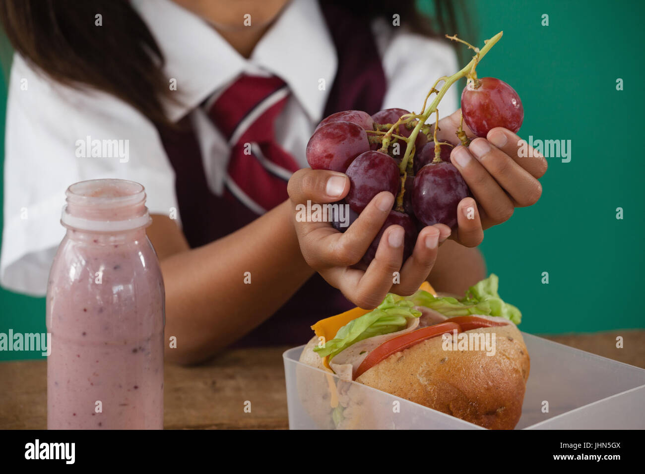 Mid-section of schoolgirl having grape fruit Stock Photo - Alamy
