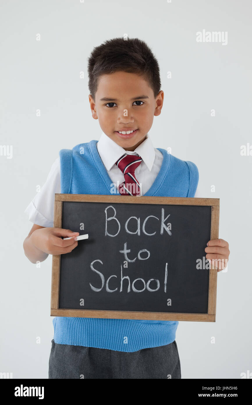 Portrait of schoolboy holding writing slate with text back to school ...