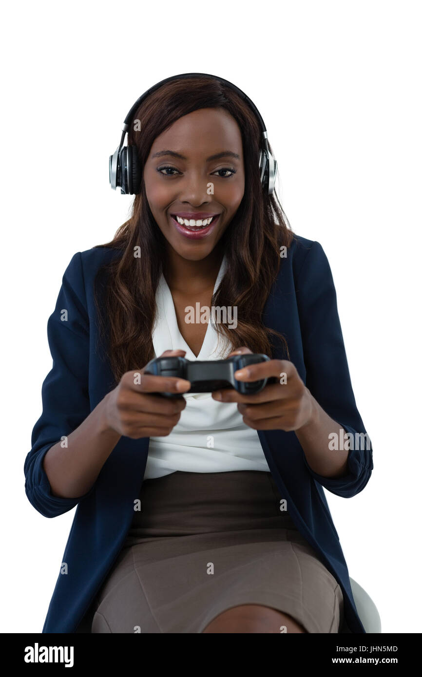 Woman wearing headphones while playing video game against white ...