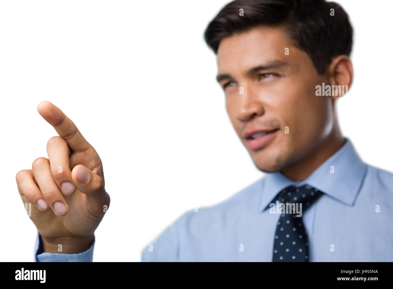 Confident young businessman using invisible interface against white ...