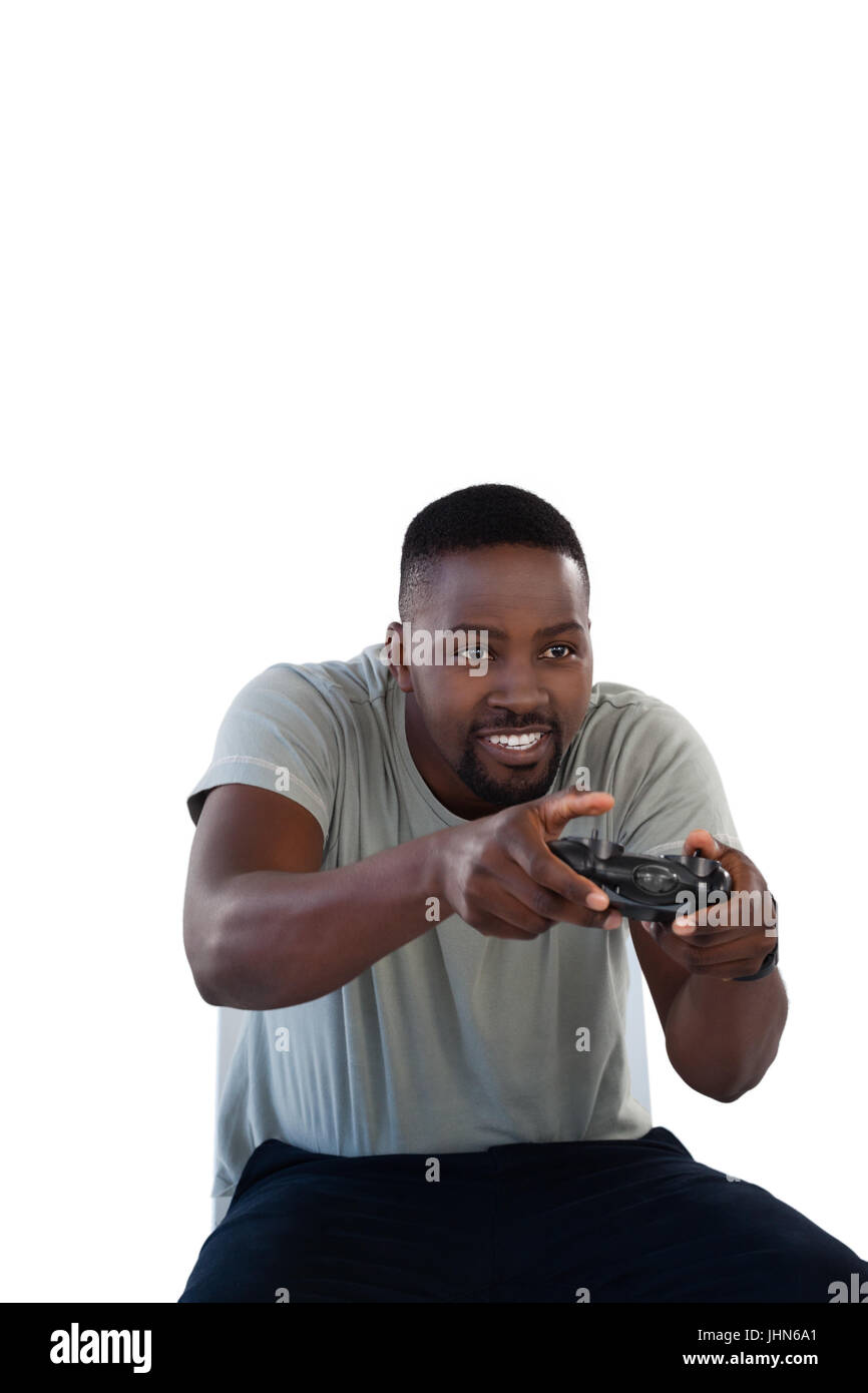 Smiling man playing video game against white background Stock Photo - Alamy
