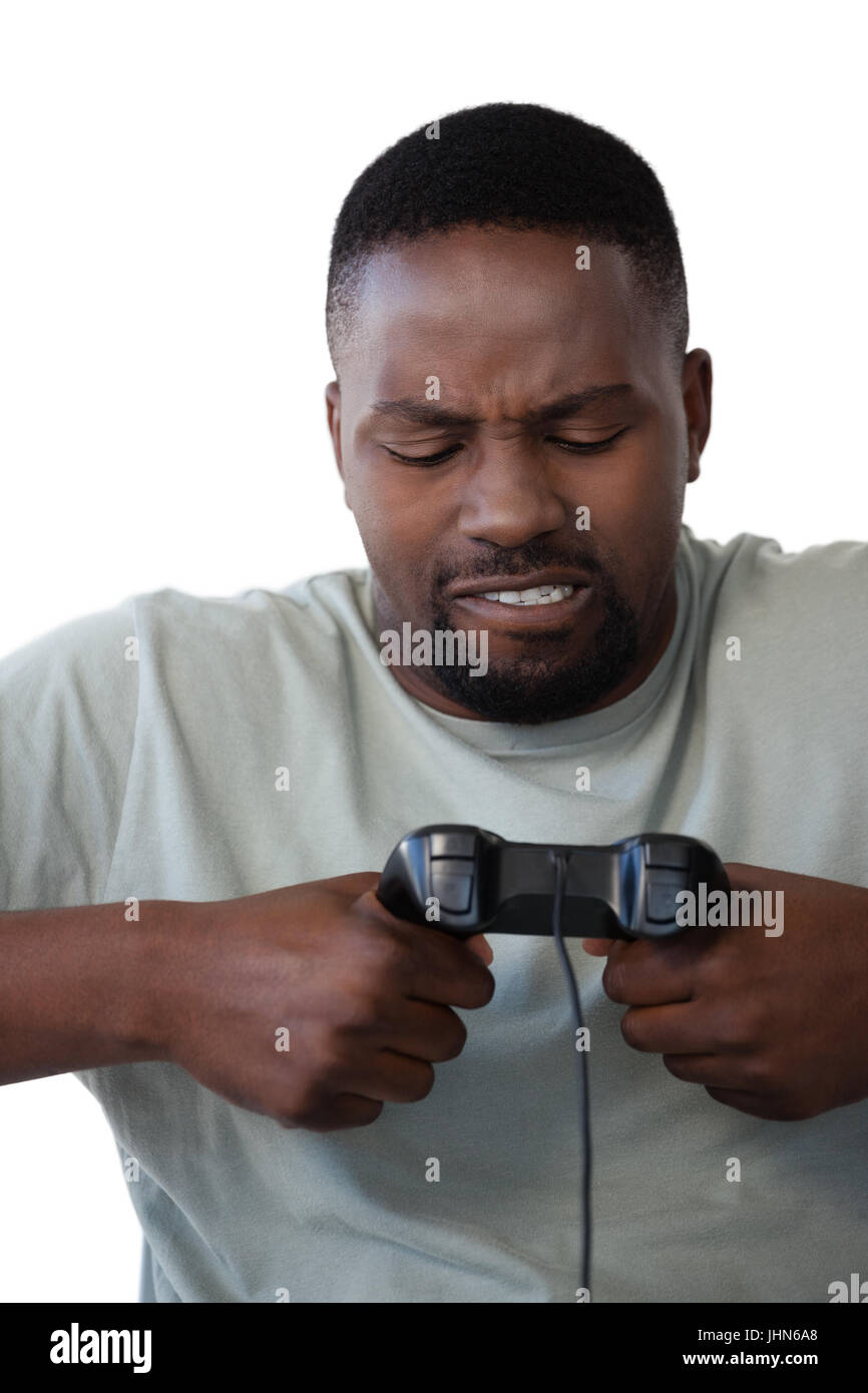 Close-up of frustrated man holding joystick against white background ...