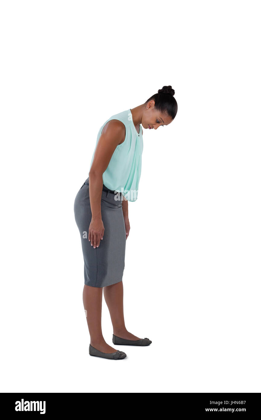 Businesswoman bending and looking down against white background Stock ...