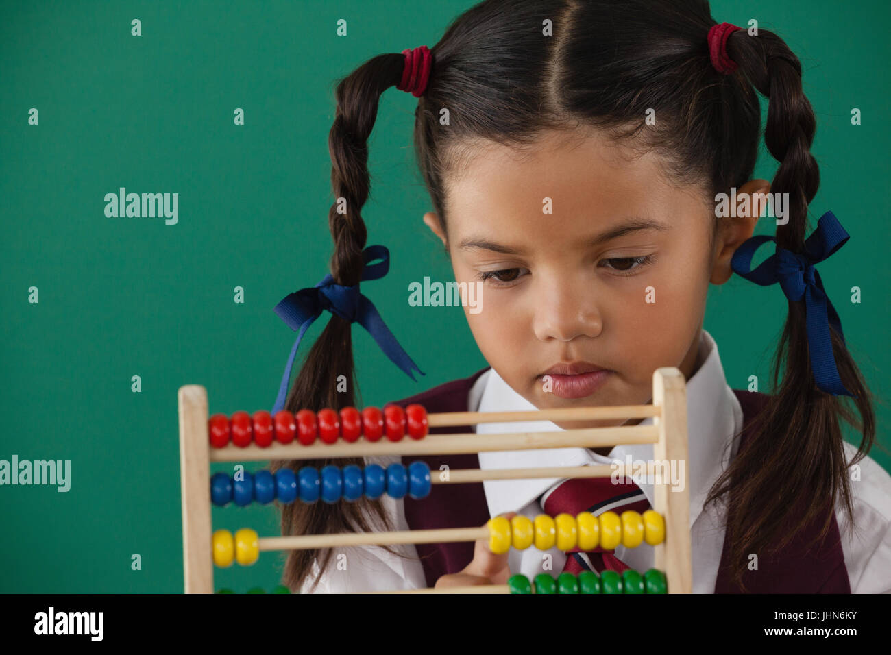 Schoolgirl using abacus against chalkboard in classroom Stock Photo - Alamy