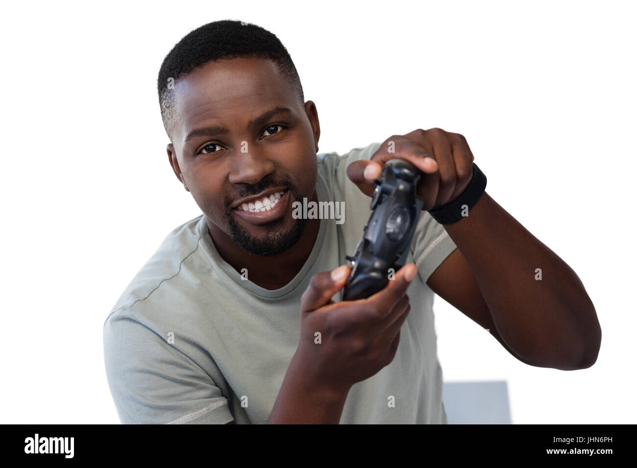 Smiling man playing video game against white background Stock Photo - Alamy