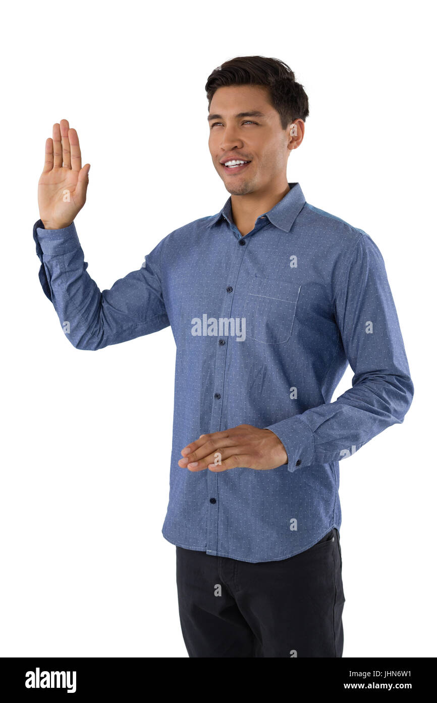 Smiling businessman waving hand while standing against white background ...
