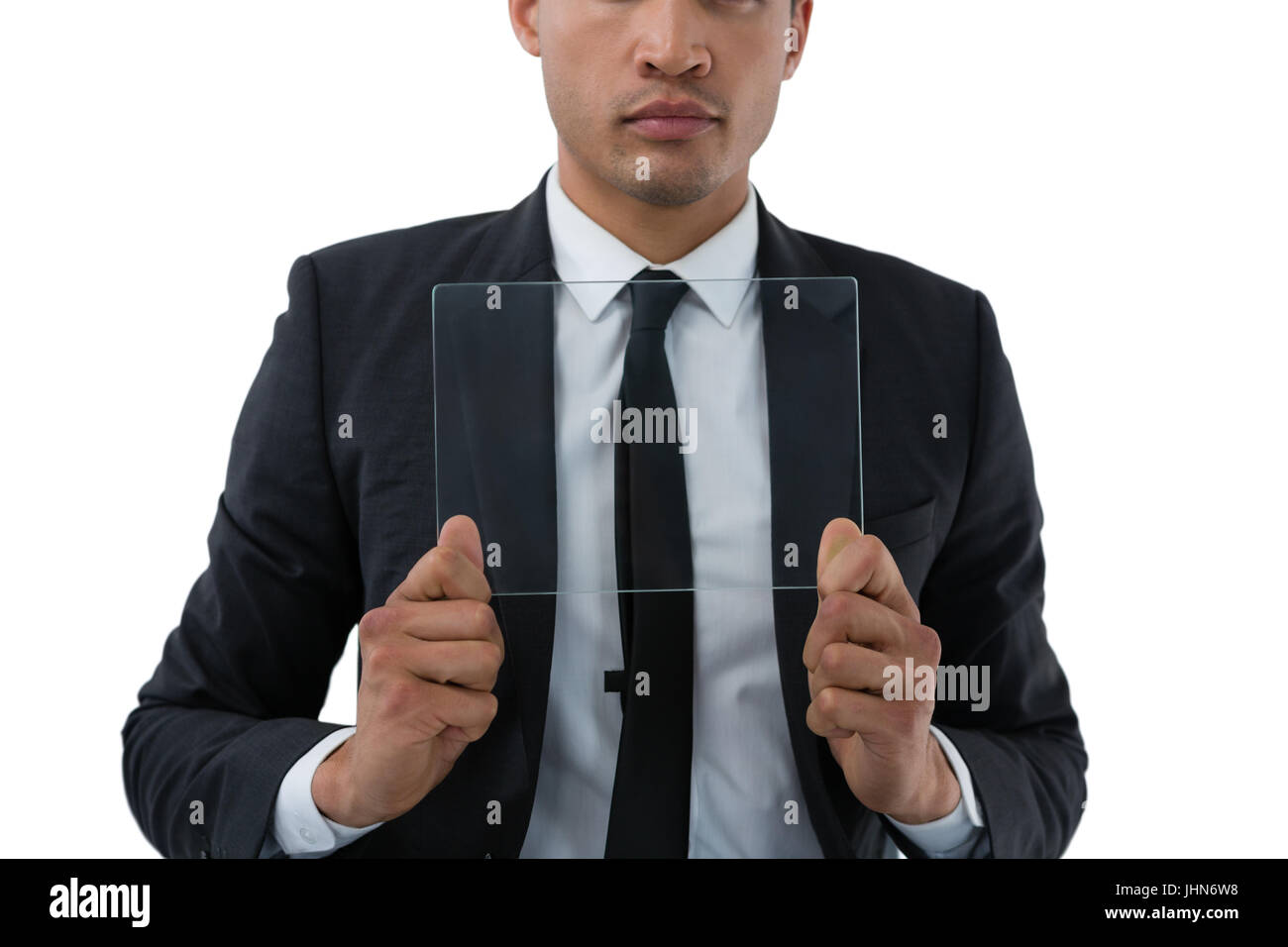 Mid section of businessman holding transparent interface against white ...