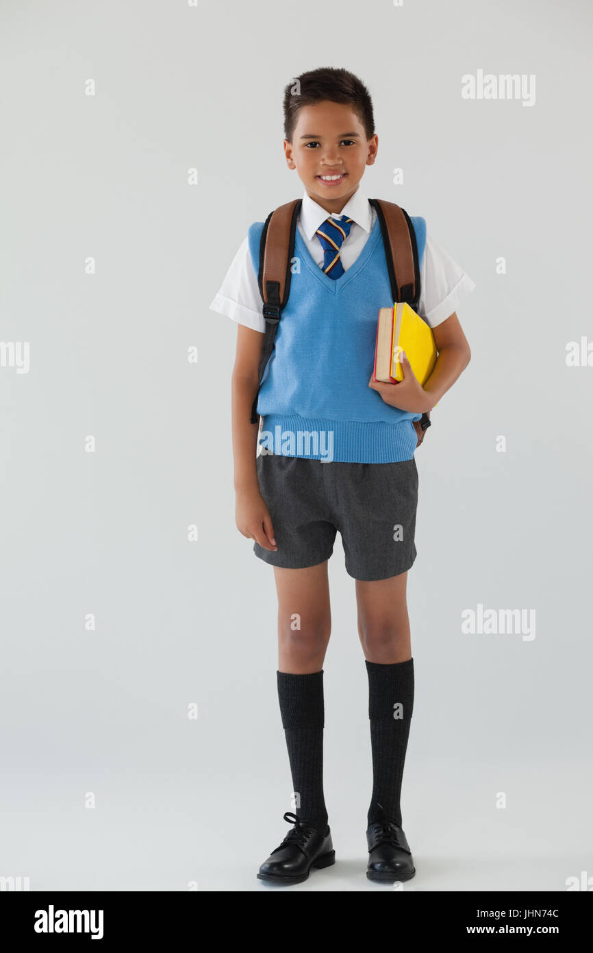 Portrait of schoolboy in school uniform with school bag on white ...
