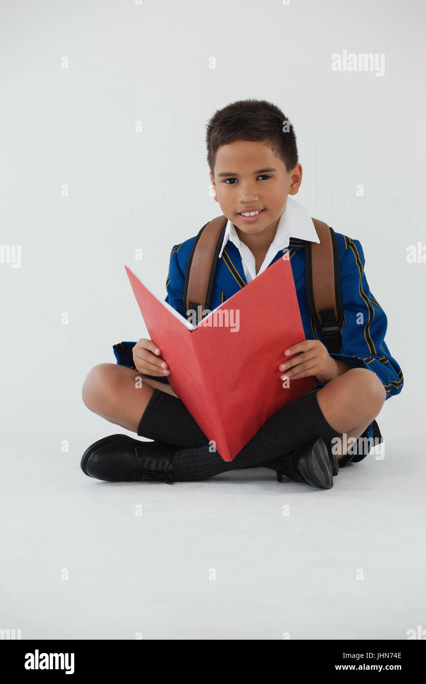 Portrait of schoolboy reading book on white background Stock Photo - Alamy
