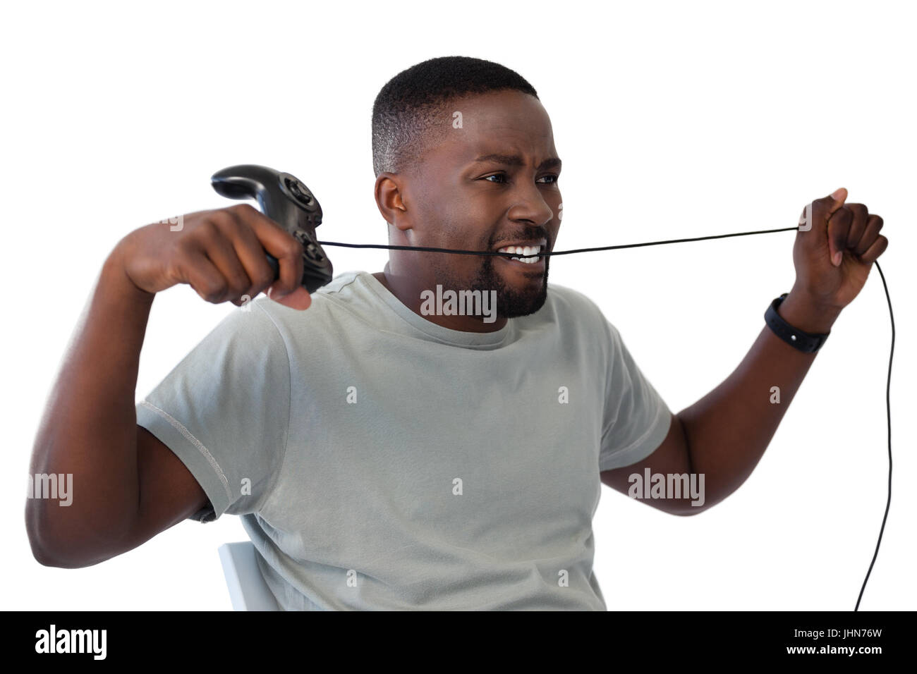Frustrated man biting a wire of joystick against white background Stock ...