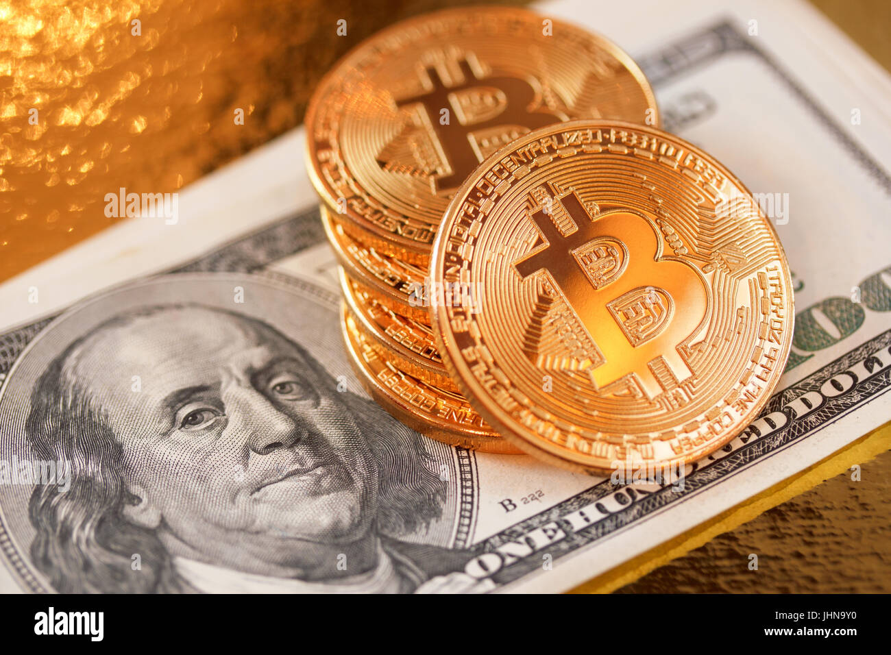 Golden bitcoin on a gold background Stock Photo - Alamy