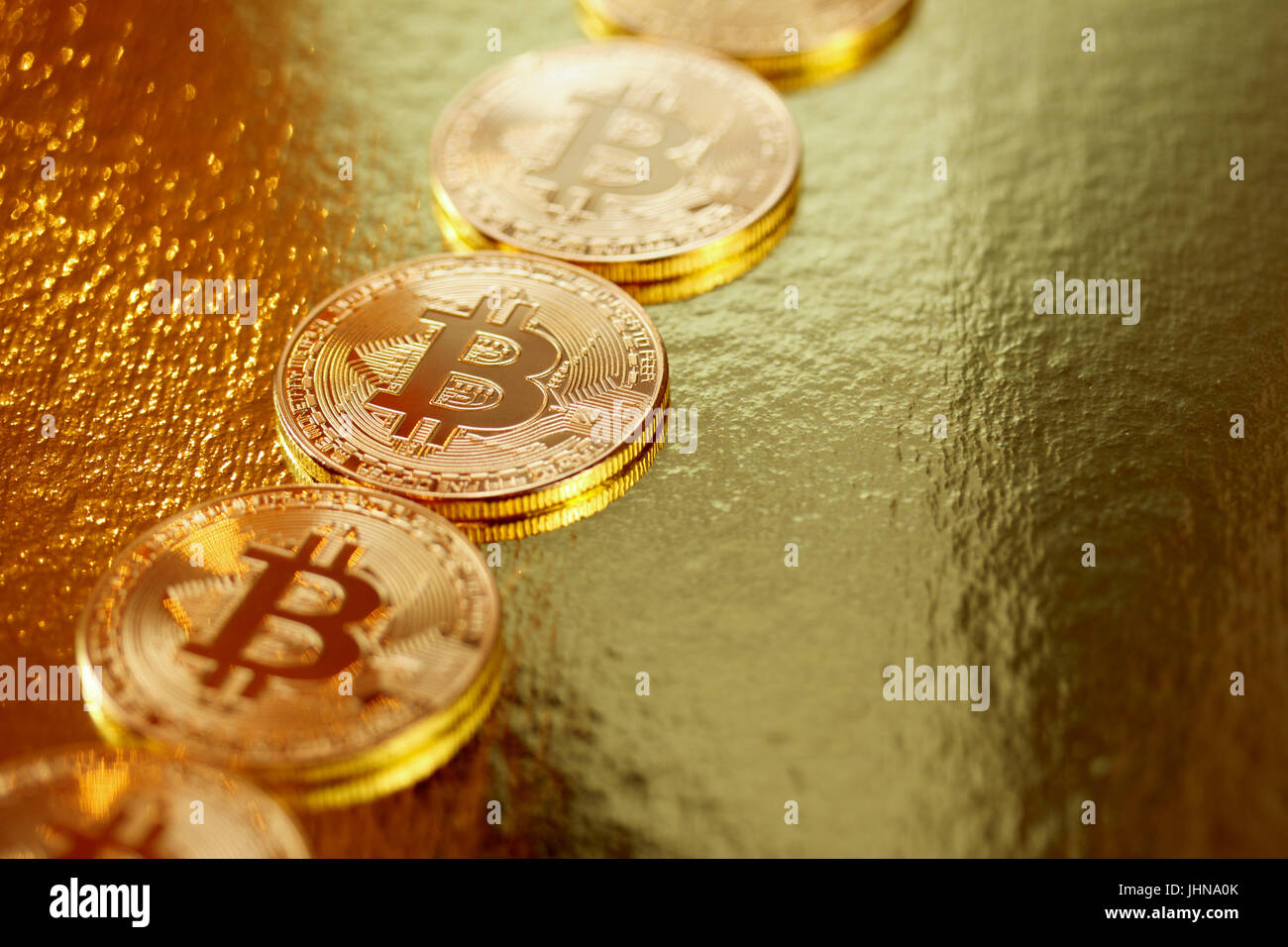 Golden bitcoin on a gold background Stock Photo - Alamy