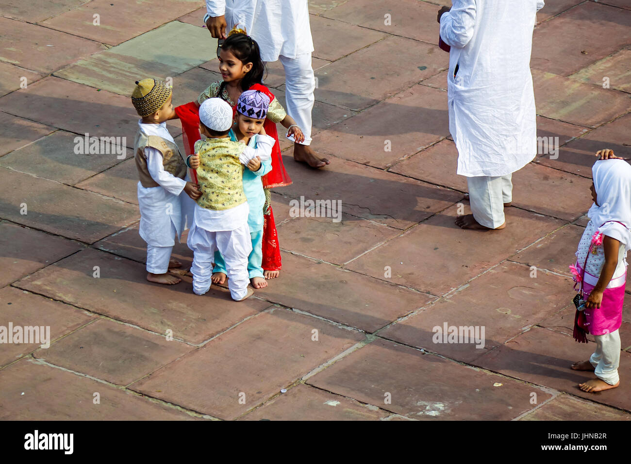 Muslim kids playing, hugging in ground of jama masjid mosque and ce ...