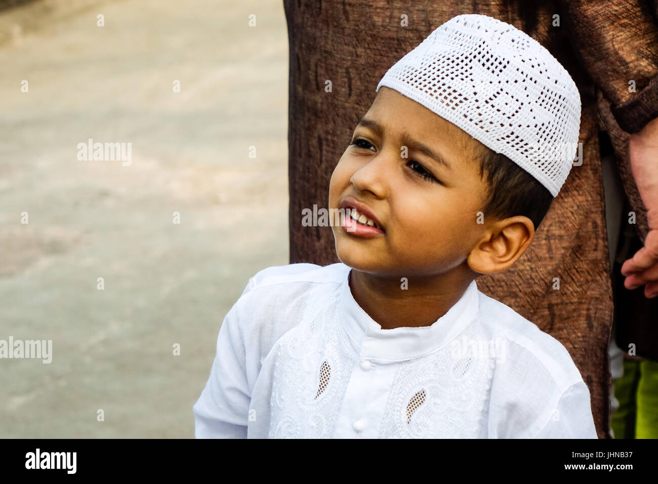 A adorable muslim boy dressed well and enjoying on occasion of Eid Al ...