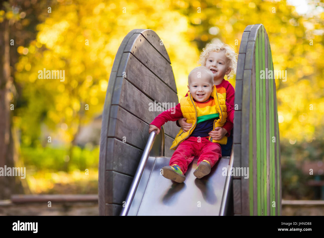 Kids on playground Children play in autumn park. Child on slide and ...