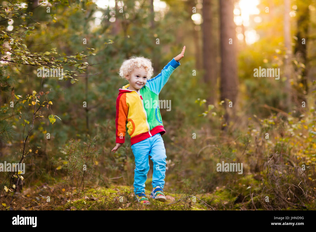 Kids play in autumn park. Children throwing yellow and red leaves ...