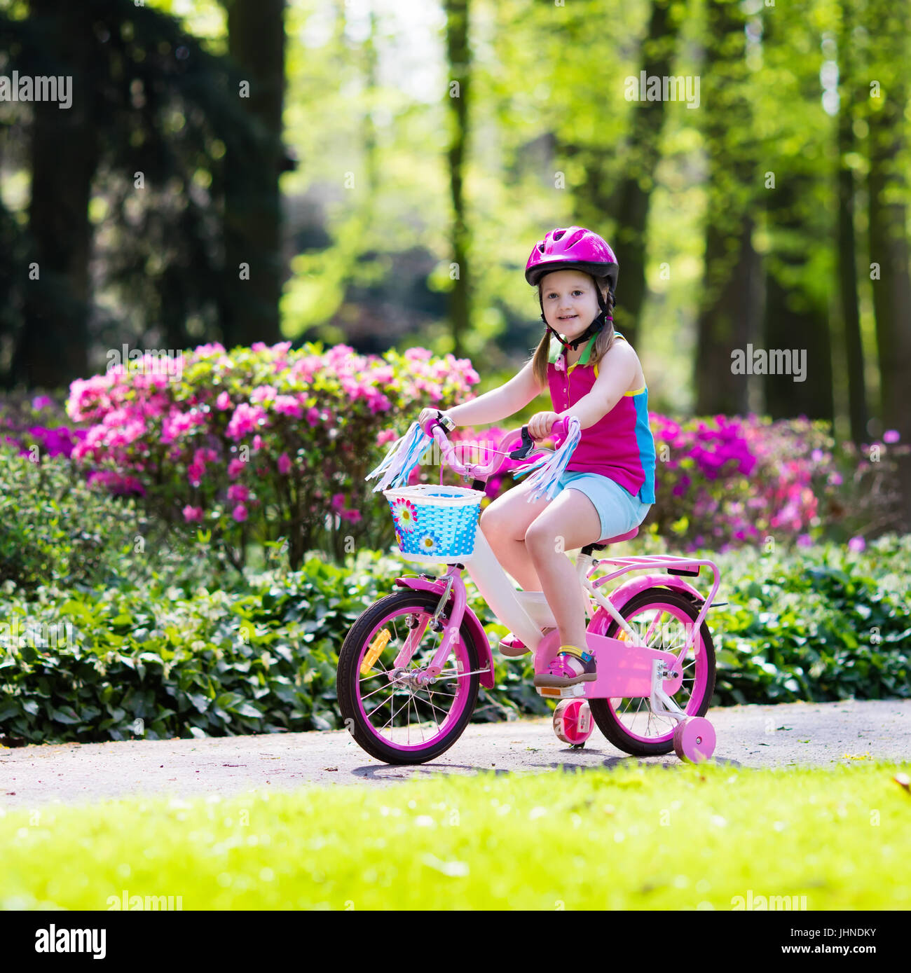 Child riding bike. Kid on bicycle in sunny park. Little girl enjoying ...