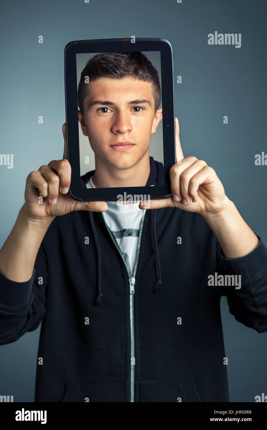 portrait of boy holding tablet with his face on it Stock Photo - Alamy