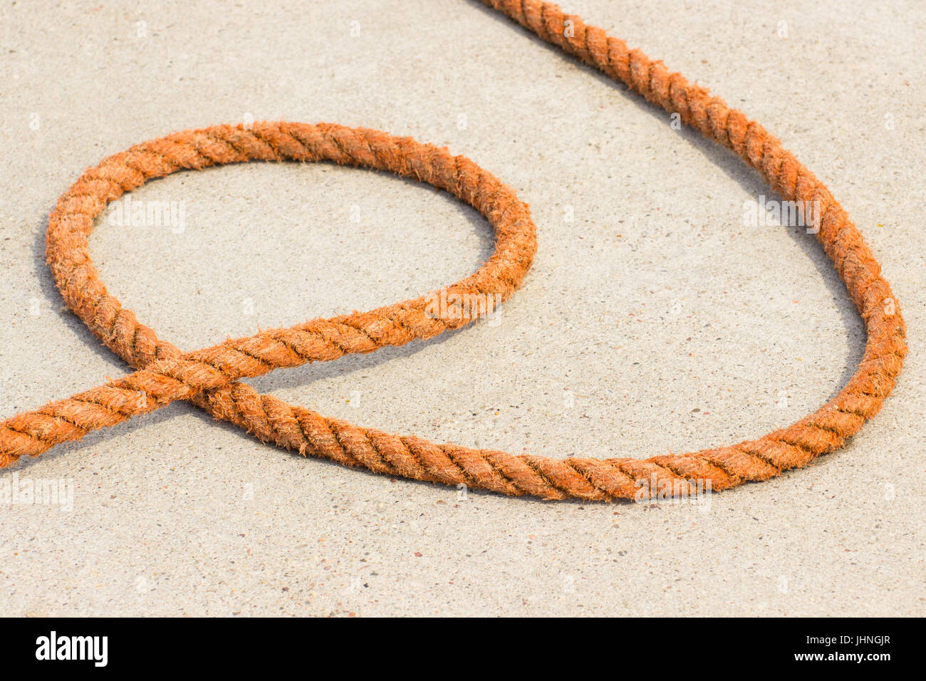 Orange rope lying on concrete in port, detail of yachting Stock Photo ...