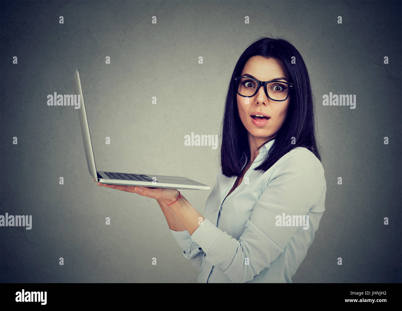Surprised woman with laptop computer Stock Photo - Alamy