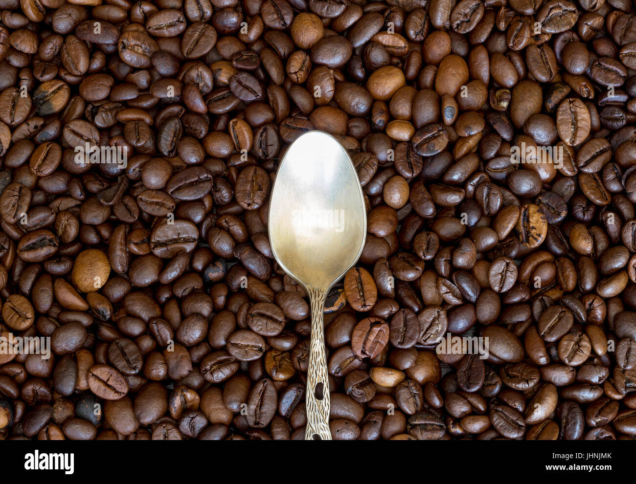 silver spoon and coffee beans as the background Stock Photo - Alamy