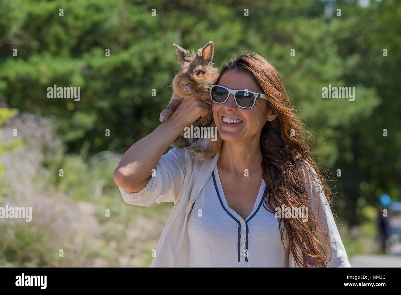 A brunette woman with a rabbit on a walk Stock Photo - Alamy