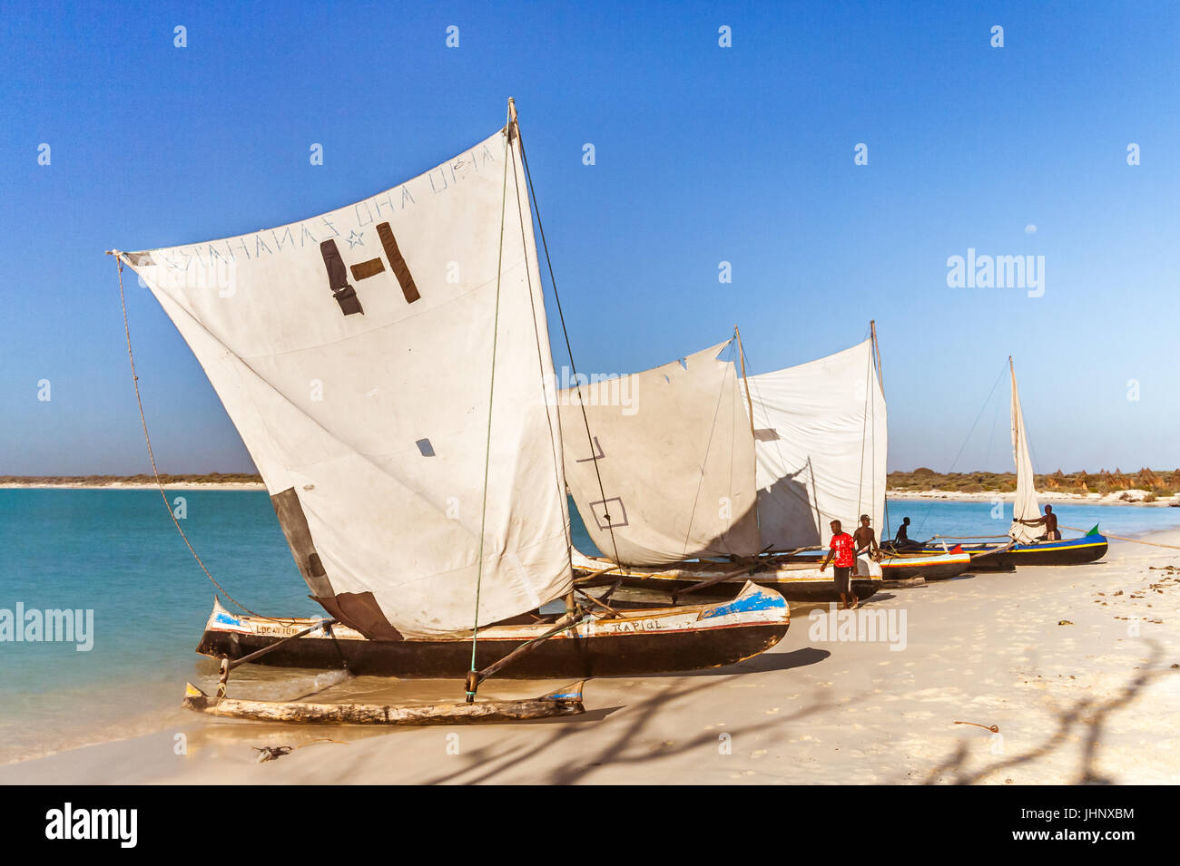 Vezo boatmen and their outrigger canoes in the Ambatomilo lagoon in ...