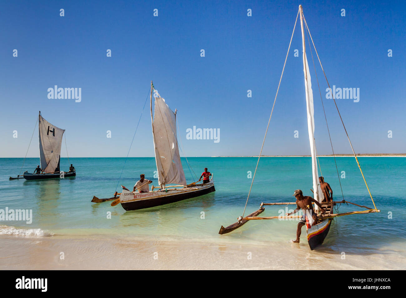 Vezo boatmen on their outrigger canoes in the Ambatomilo lagoon in ...