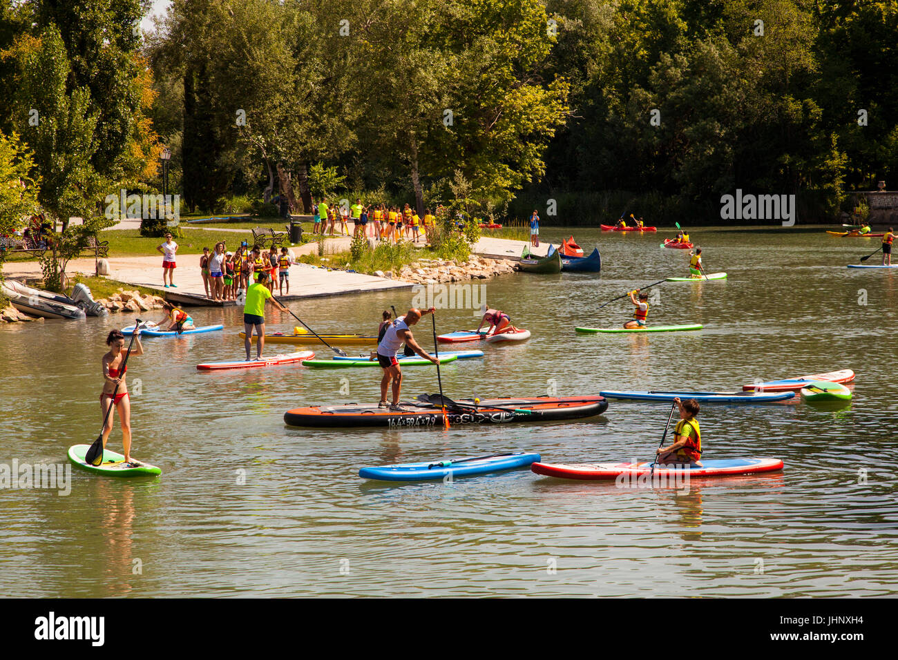 Children learning paddle boarding on the River Tagus / Tajo as it flows ...