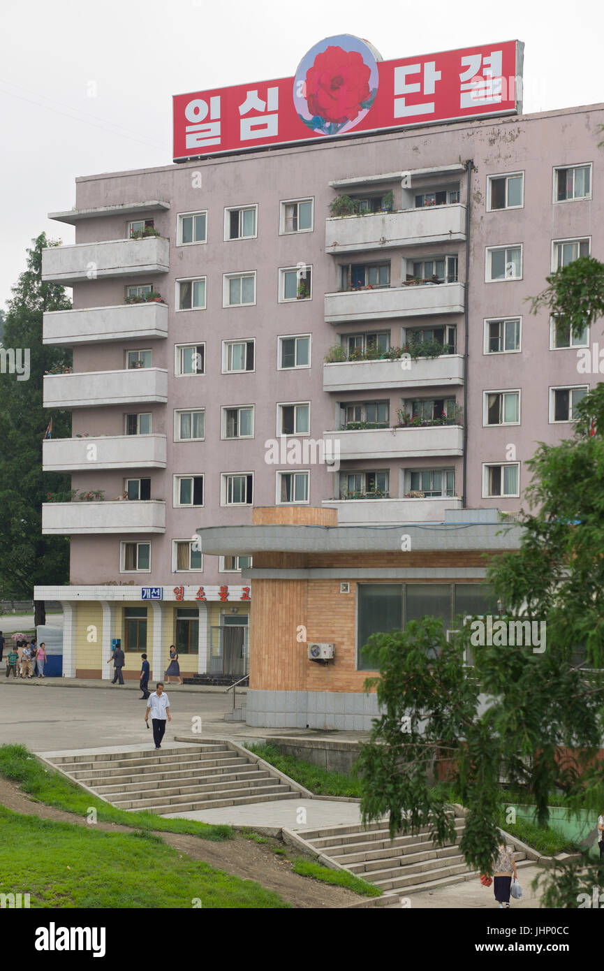 Ground floor shop and with multi-storey partment block above and slogan ...
