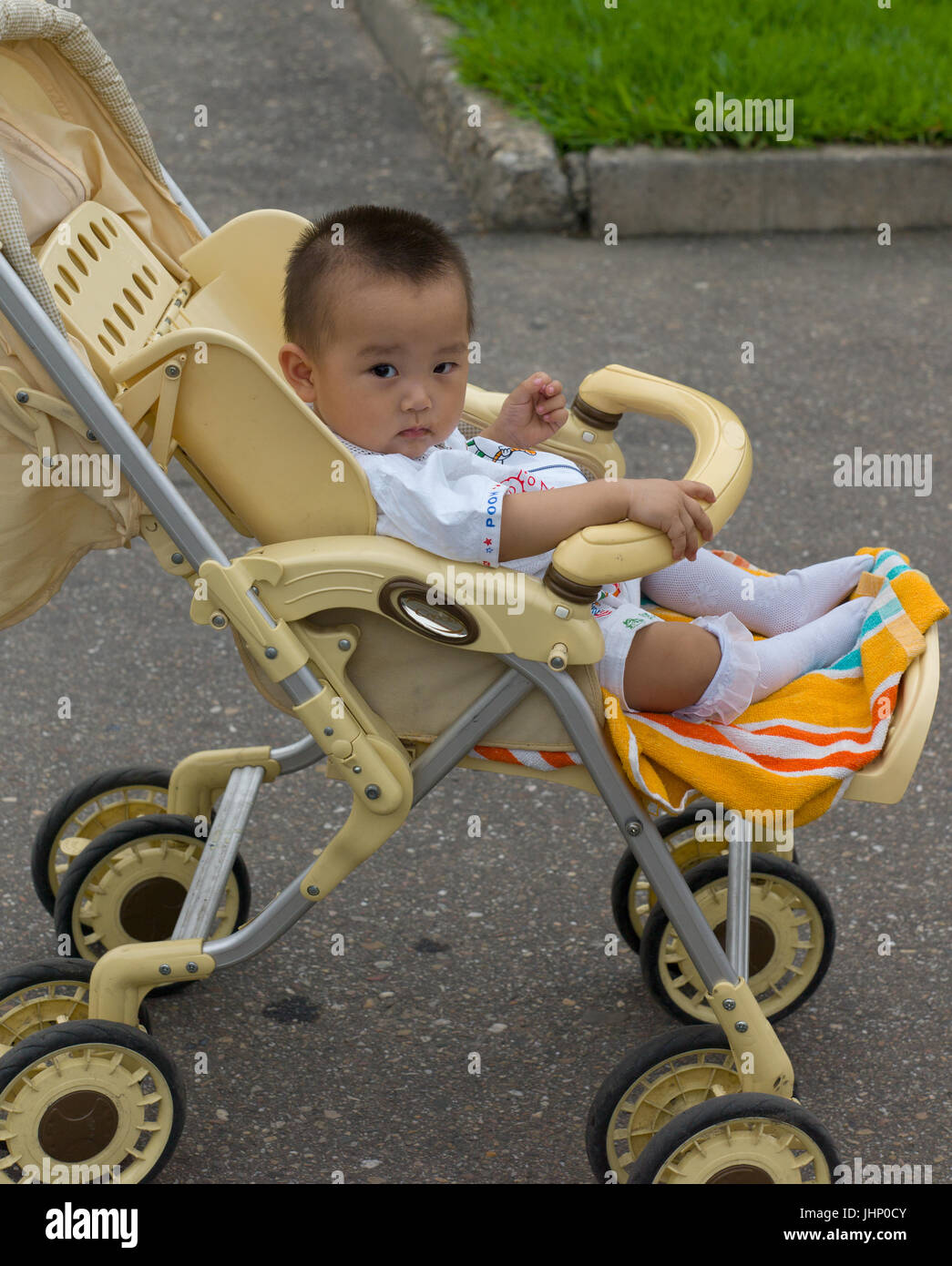 Young child sitting in pushchair and looking at camera. Pyongyang, DPRK ...