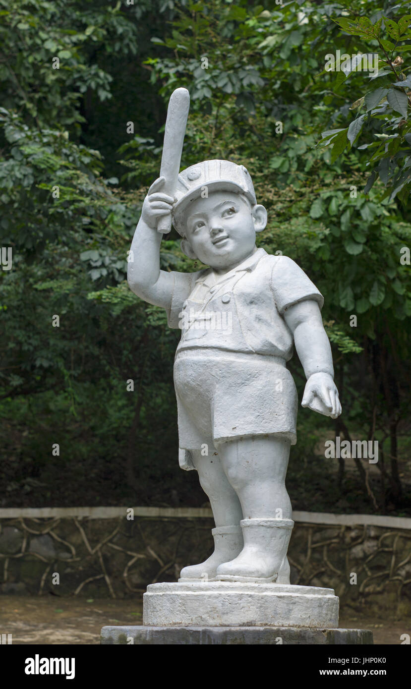 Statue of young man in uniform pointing upward with baton towards top ...