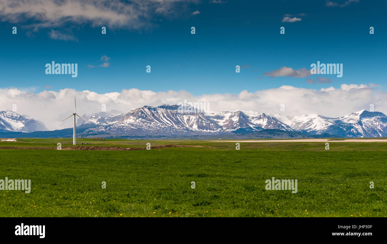 Prairie farmland and wind turbines in the shadow of the Rocky Mountains ...