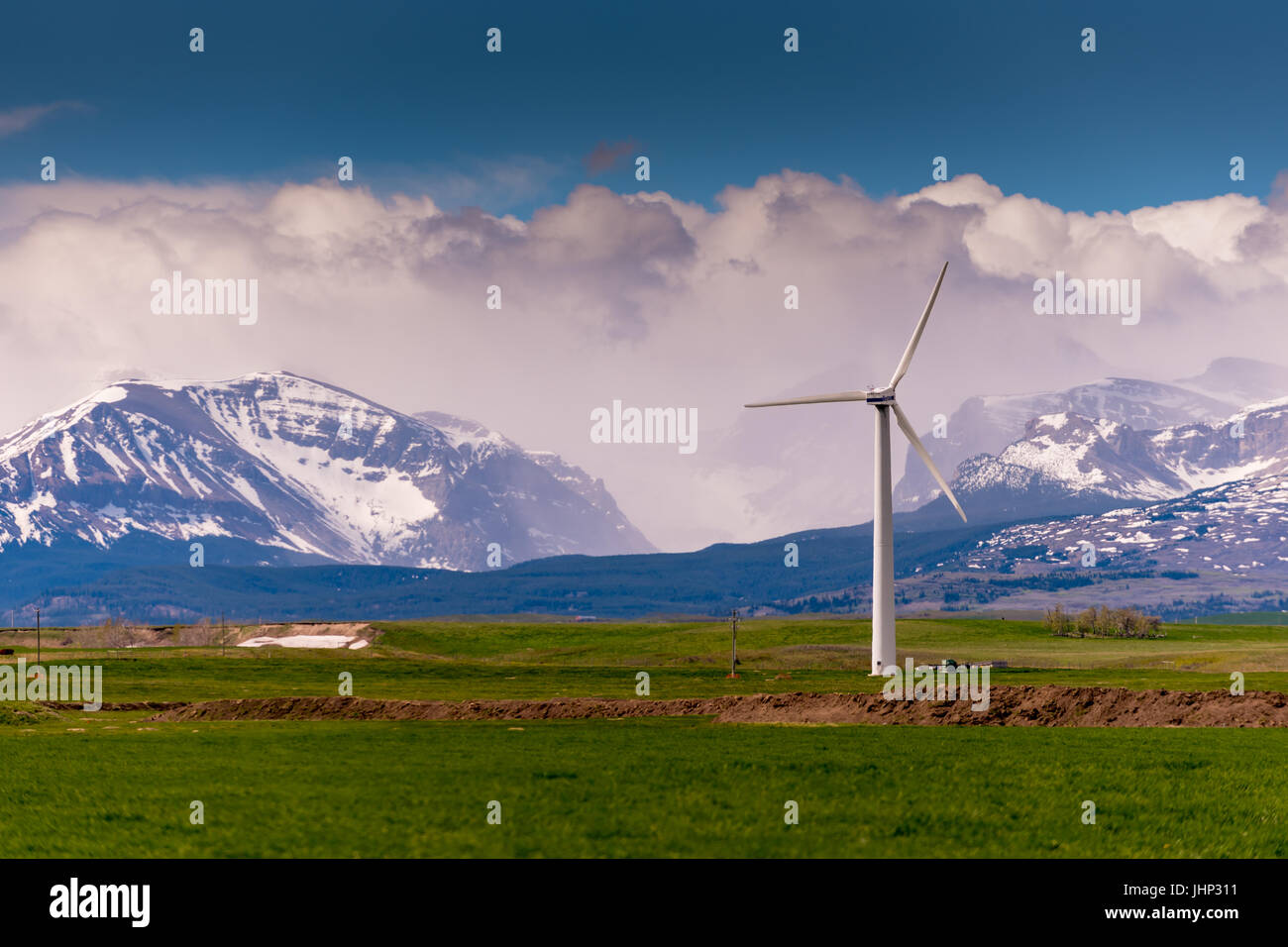 Prairie farmland and wind turbines in the shadow of the Rocky Mountains ...