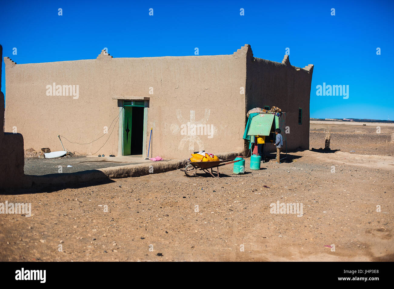 The boy carries water tanks on a wheelbarrow Stock Photo - Alamy