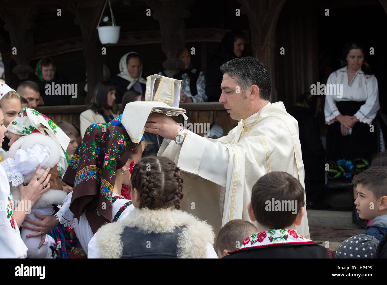 Orthodox priest blessing people in traditional costume at "Udatoriul ...