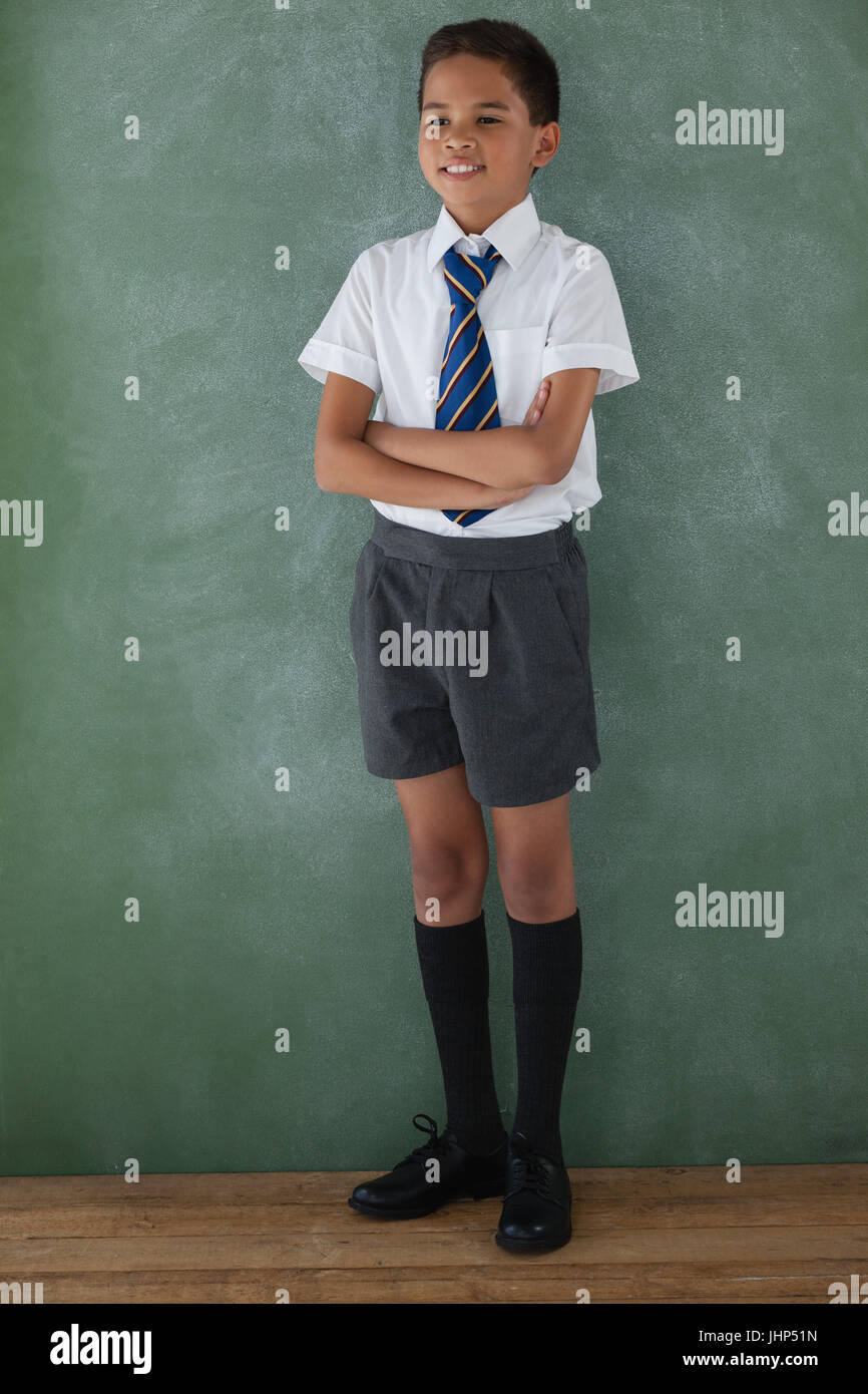Schoolboy standing in front of chalkboard in classroom at school Stock ...