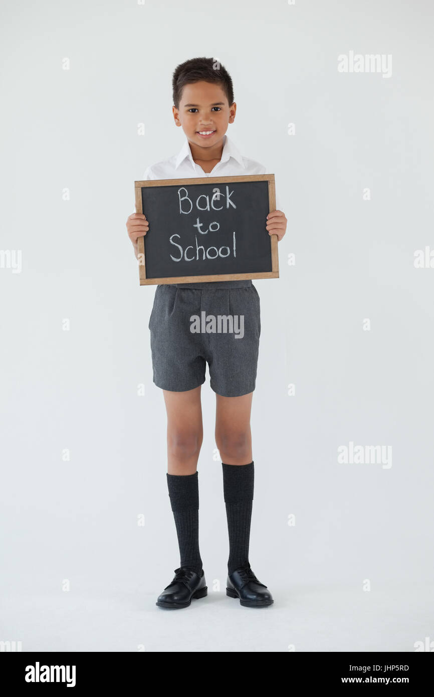 Portrait of schoolboy holding writing slate with text back to school ...