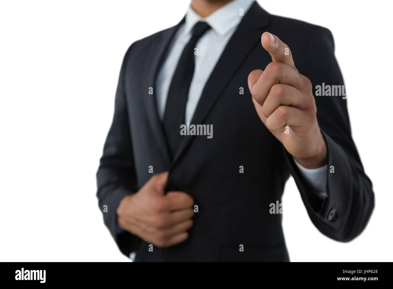 Mid section of businessman pointing while standing against white ...
