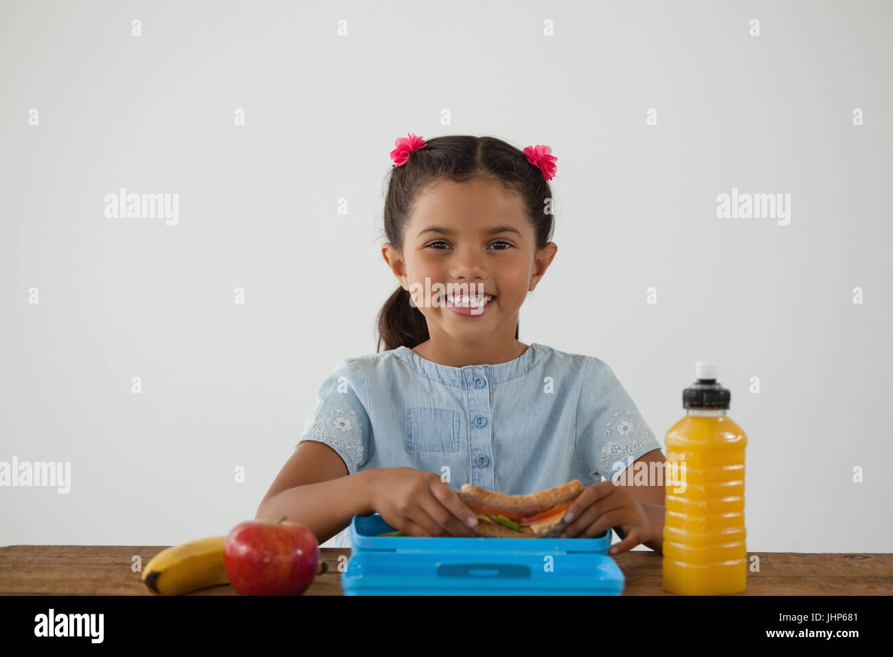 Portrait of schoolgirl having breakfast against white background Stock ...