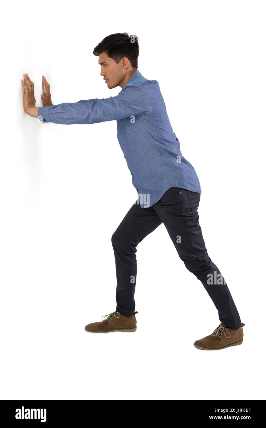 Side view of businessman pushing something against white background ...