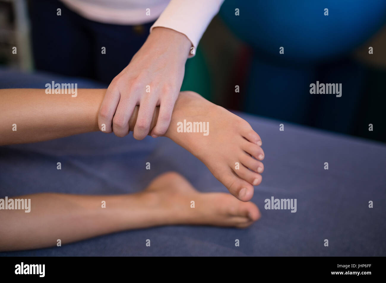 High angle view of female therapist examining feet with boy lying on ...
