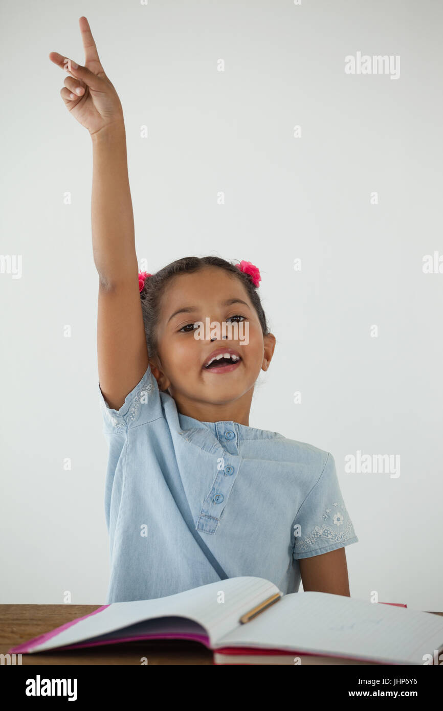Young girl raising her hand against white background Stock Photo - Alamy