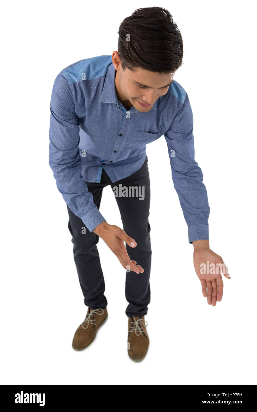Smiling businessman gesturing while bending against white backgrond ...
