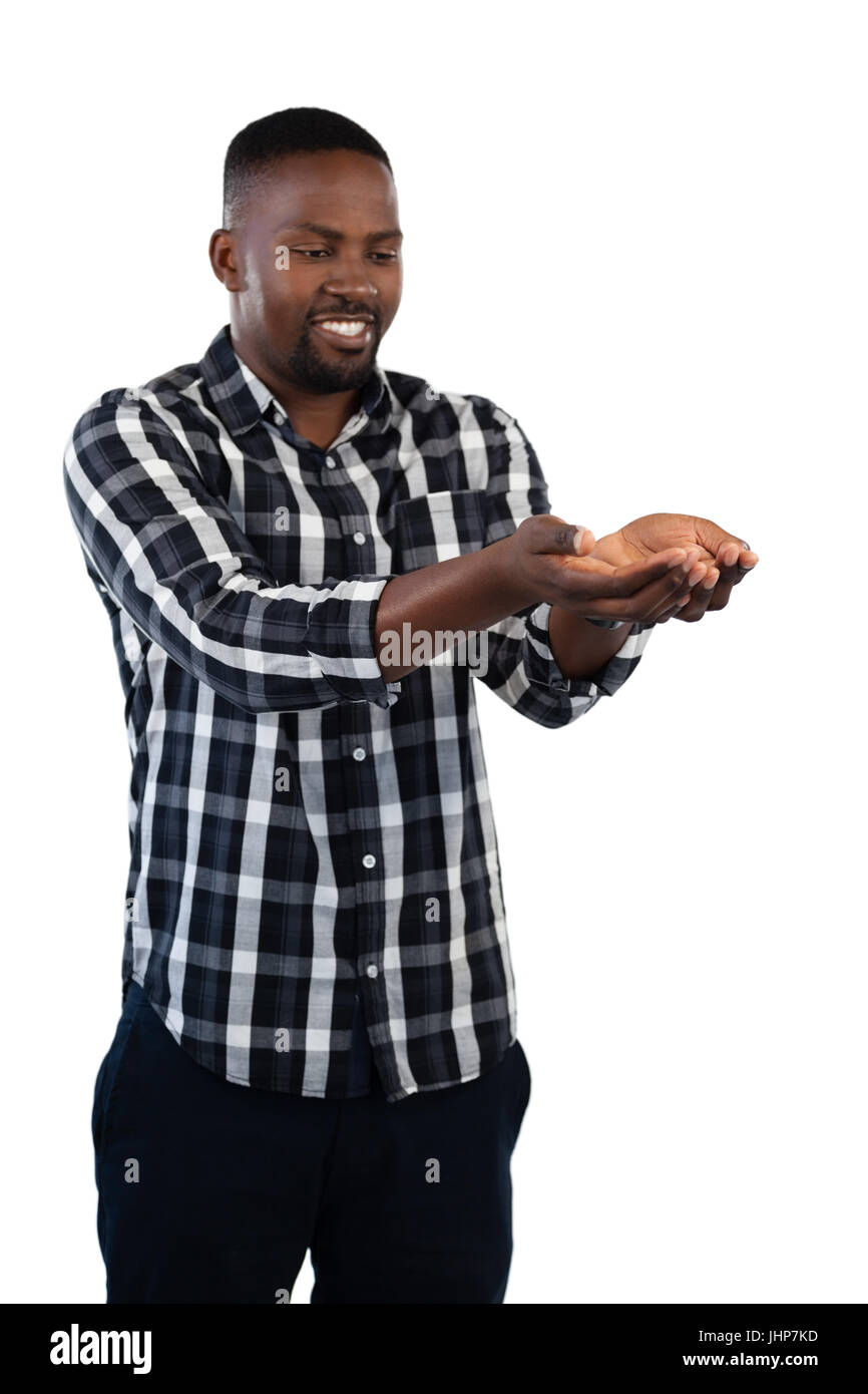 Thoughtful man standing with hands cupped against white background ...