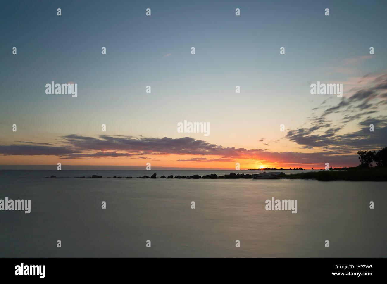 Sunset over Ocean with Breakwater and rowboat in Gotland, Sweden Stock ...